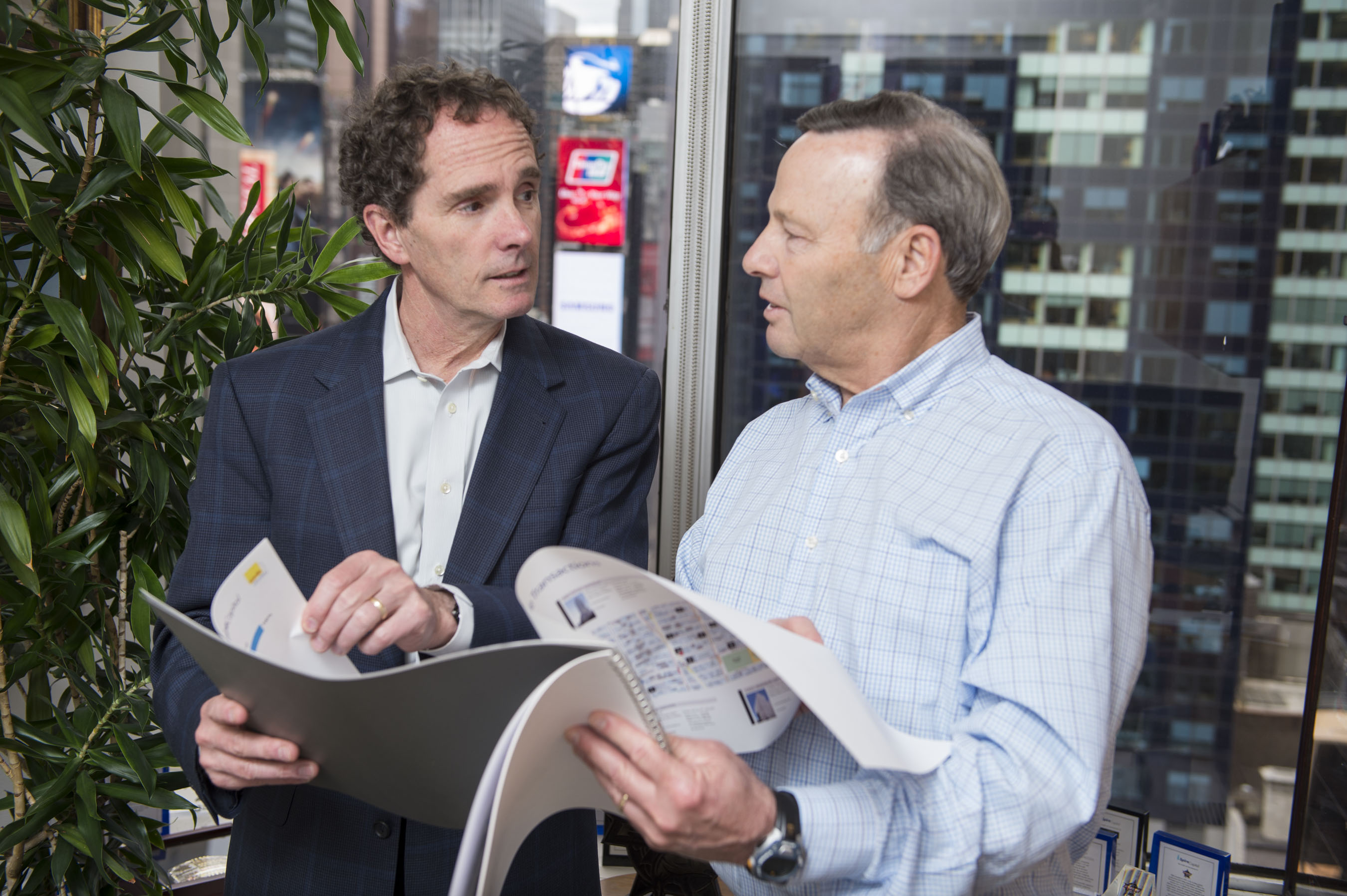 Spire Capital partners reading documents by the window - Spire Capital
